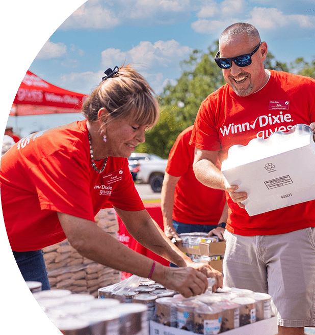 Winn-Dixie gives foundation volunteers assembling packages of canned ...